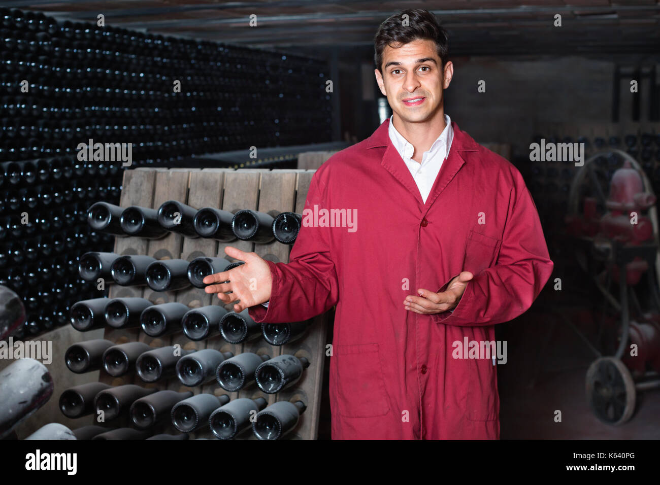 Glad smiling friendly man winery employee wearing coat working in aging ...