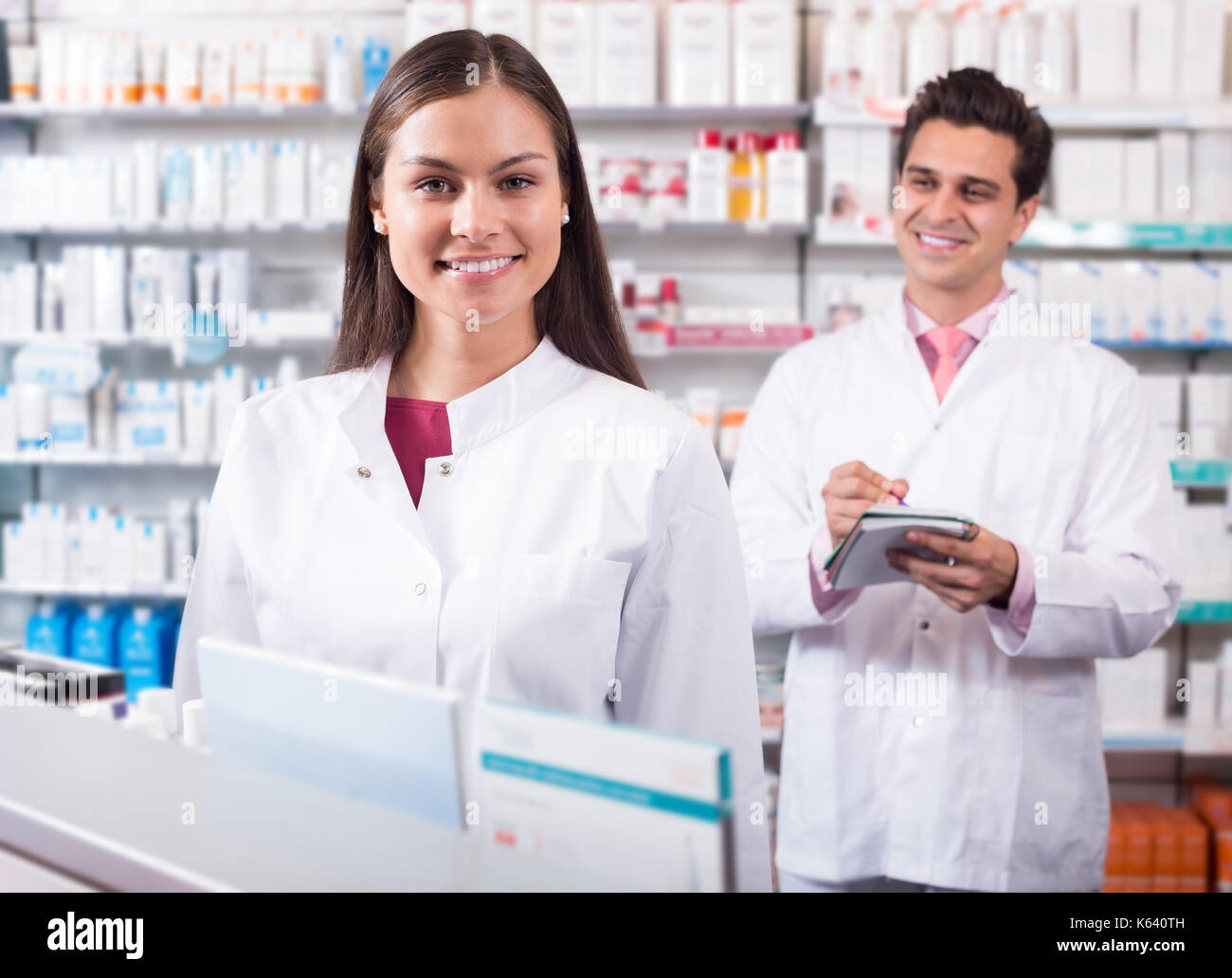 Professional smiling russian pharmaceutists at reception of drugstore ...