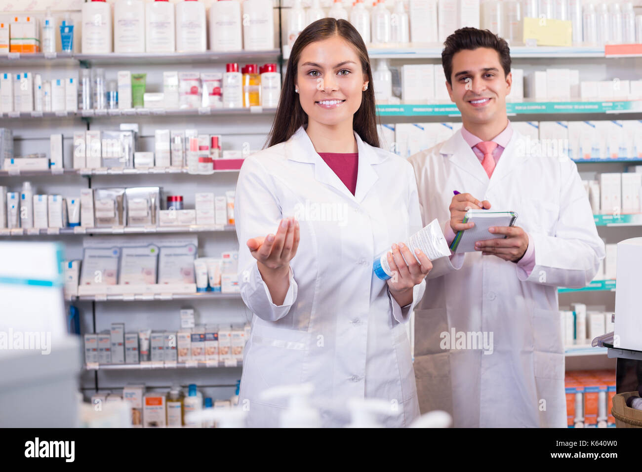 Positive pharmacist and pharmacy technician working in drugstore Stock ...
