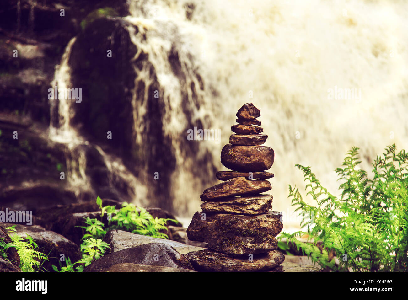 Stone pyramid near a tropical waterfall. The concept of harmony and ...