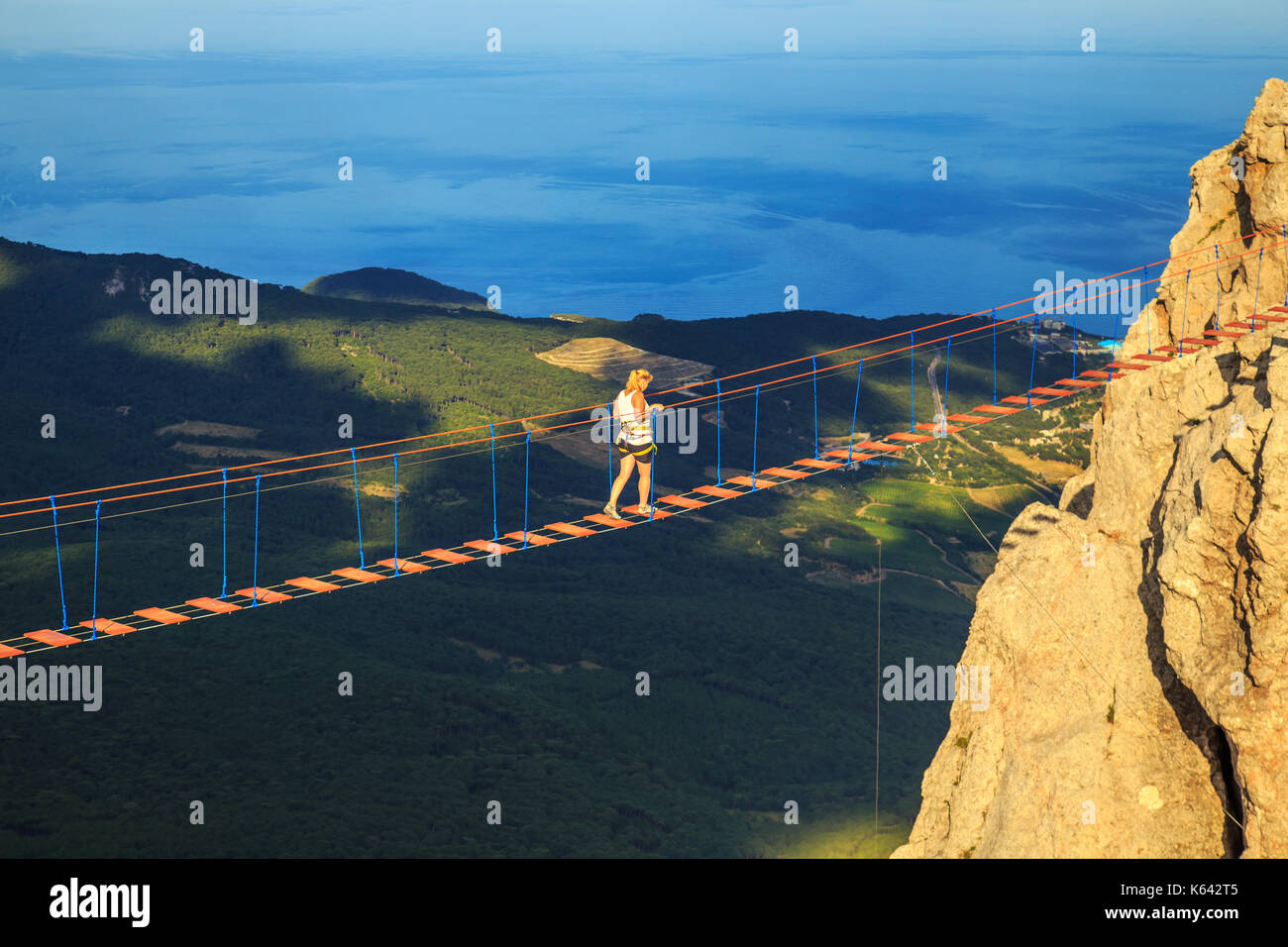 Woman is walking along a suspension bridge over an abyss. Yalta, the ...
