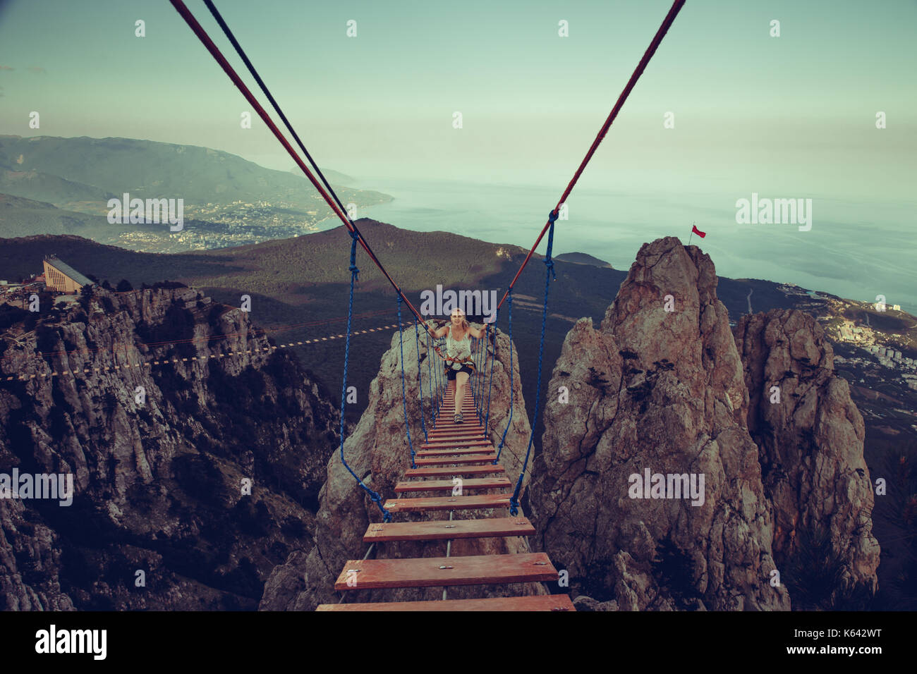 Woman is walking along a suspension bridge over an abyss. Yalta, the ...