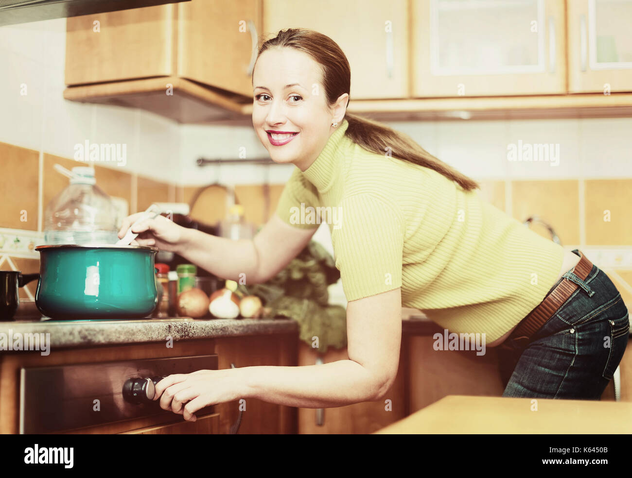 Portrait of happy housewife cooking dinner in domestic kitchen Stock ...