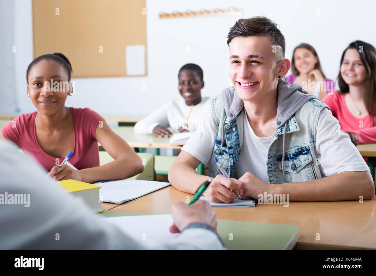 Group of cheerful girls and boys making the notes at the lesson in ...