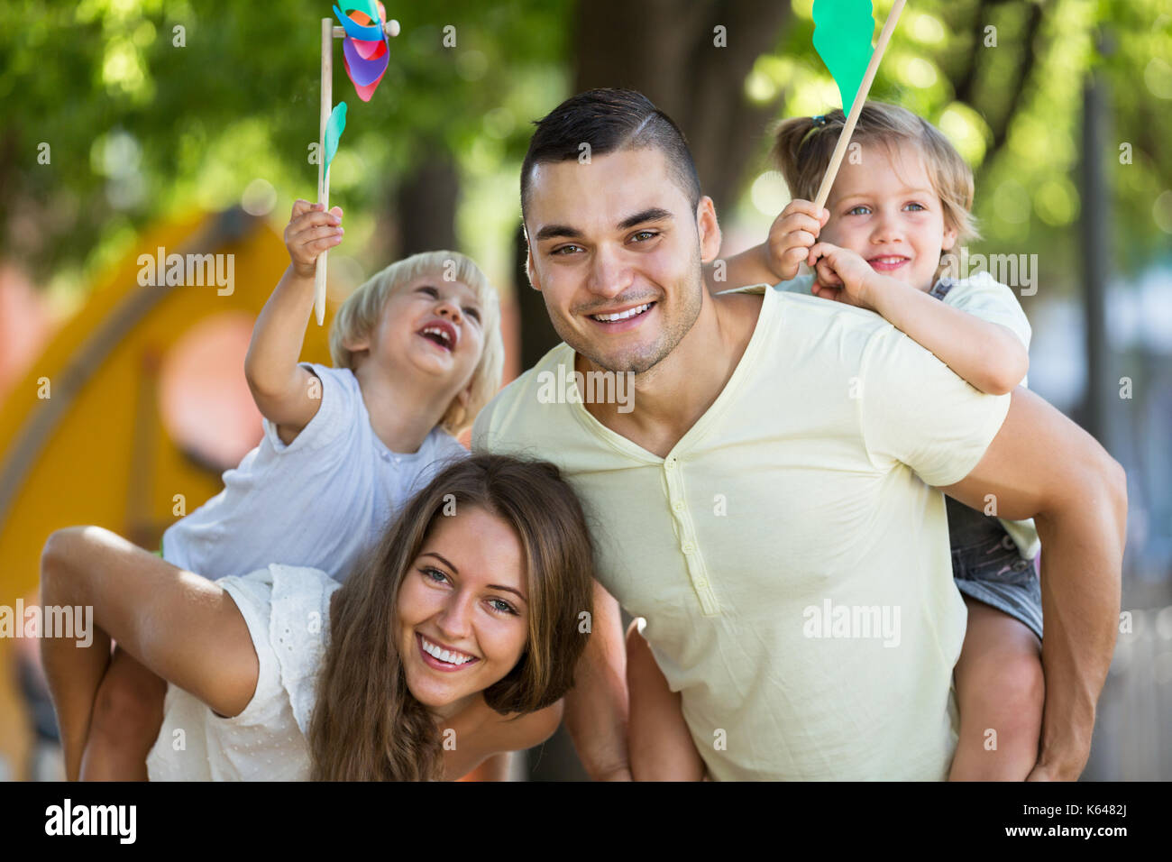 Parents walking with girls on vacation day at park Stock Photo - Alamy