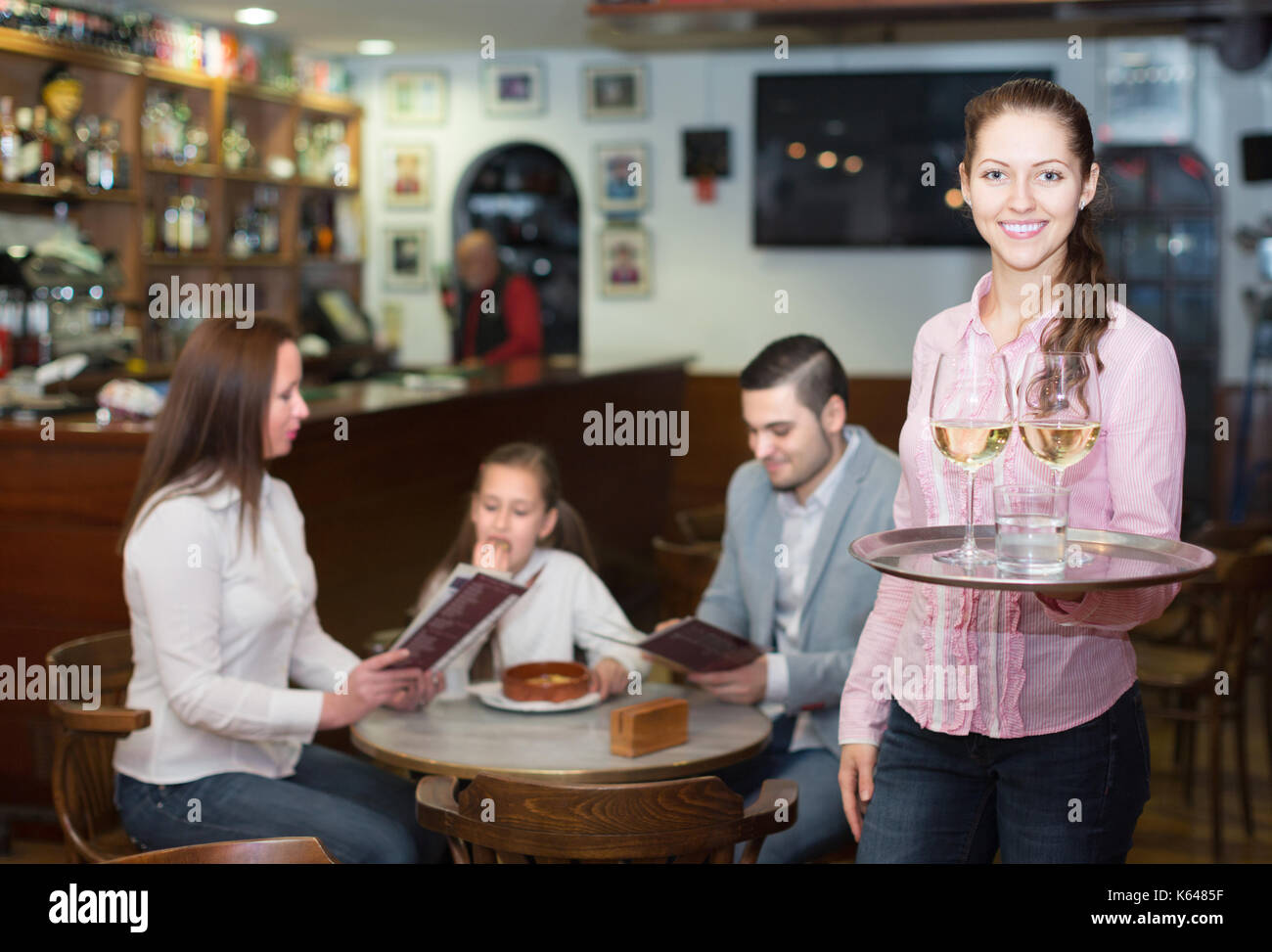 Smiling waitress and happy family with child at cafe Stock Photo - Alamy