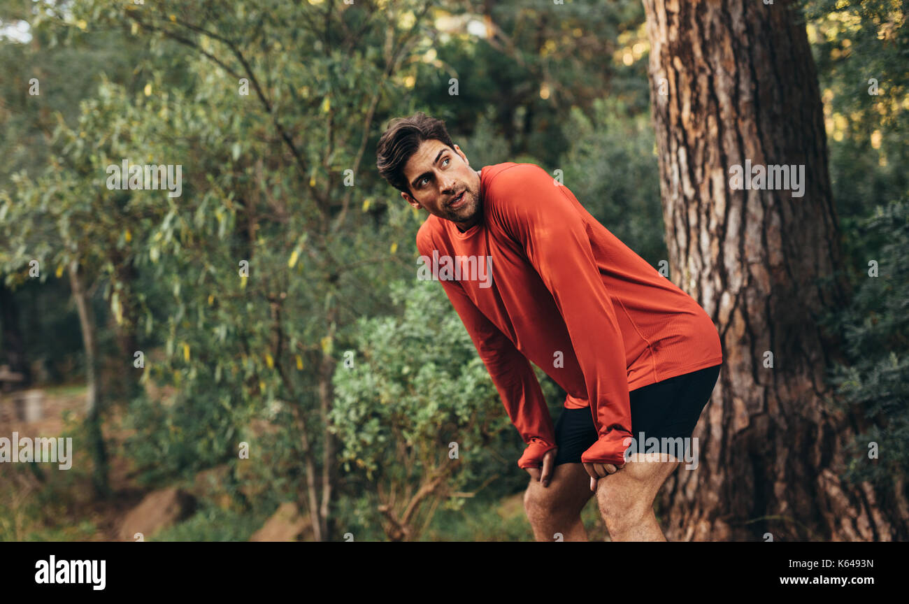 Man relaxing after intense workout. Athlete taking rest with hands ...