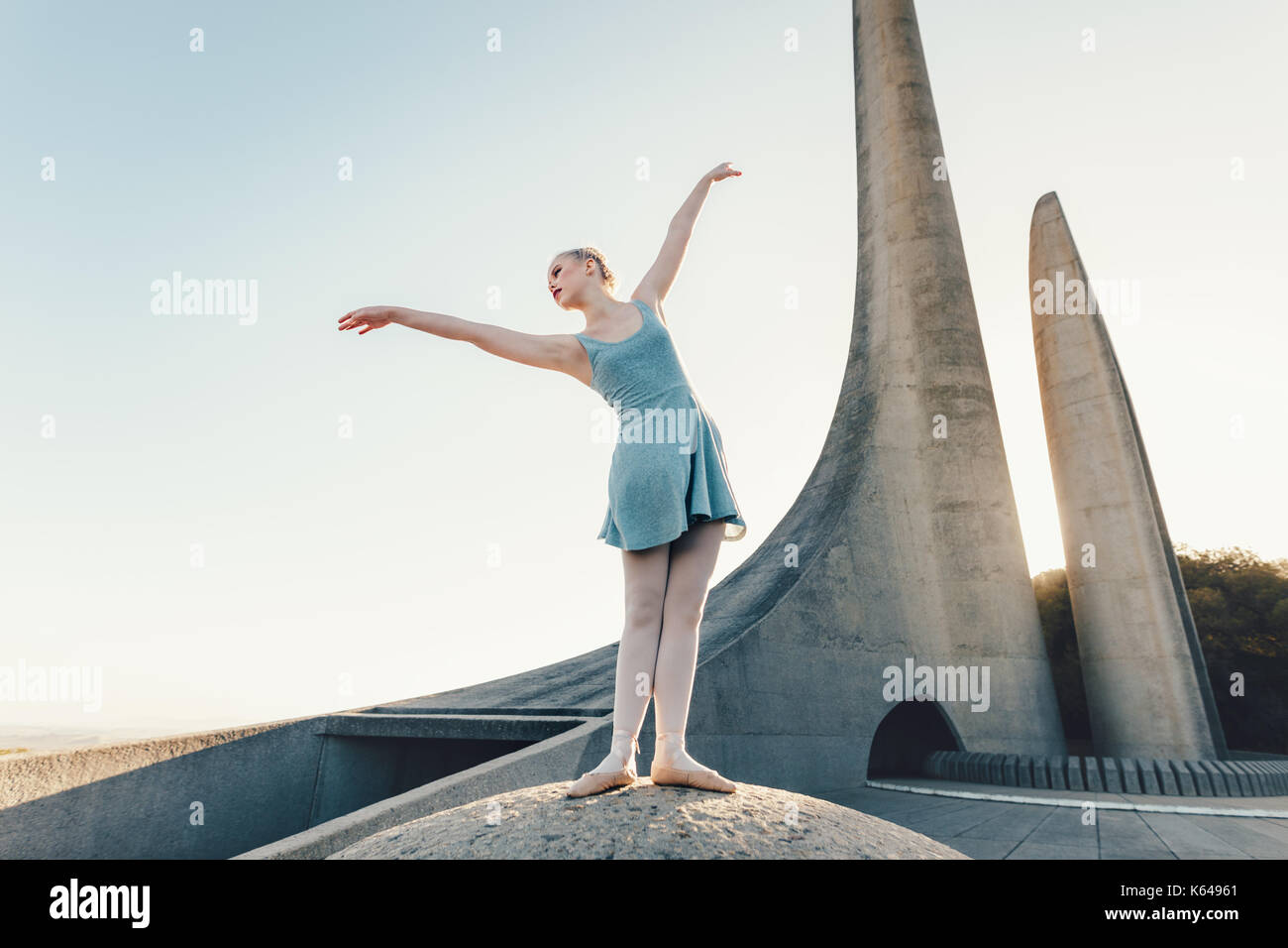 Ballet artist practicing dance moves outdoors. Female dancer standing ...