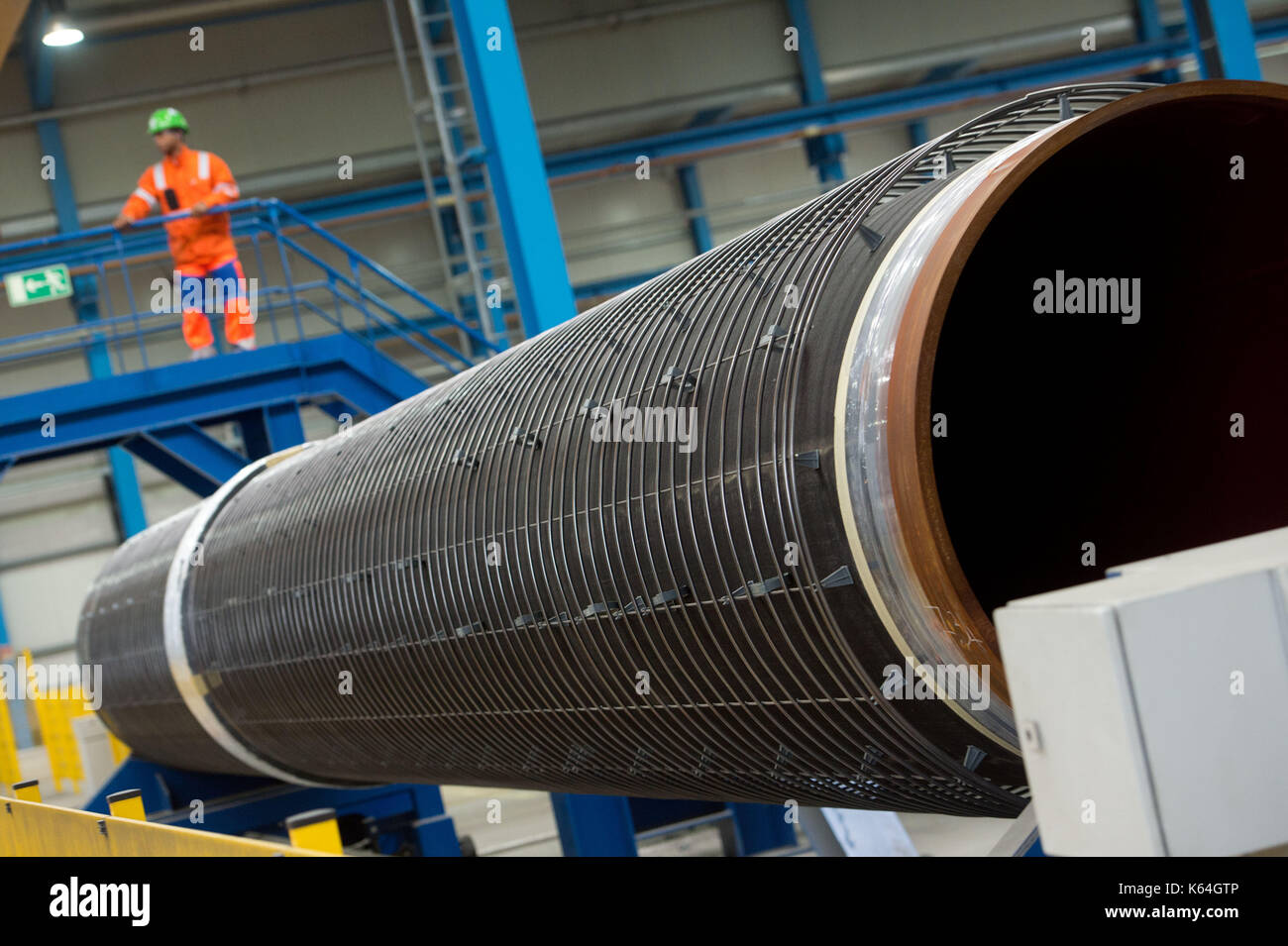 A steel pipe is being coated in concrete in the Wasco coating plant on ...