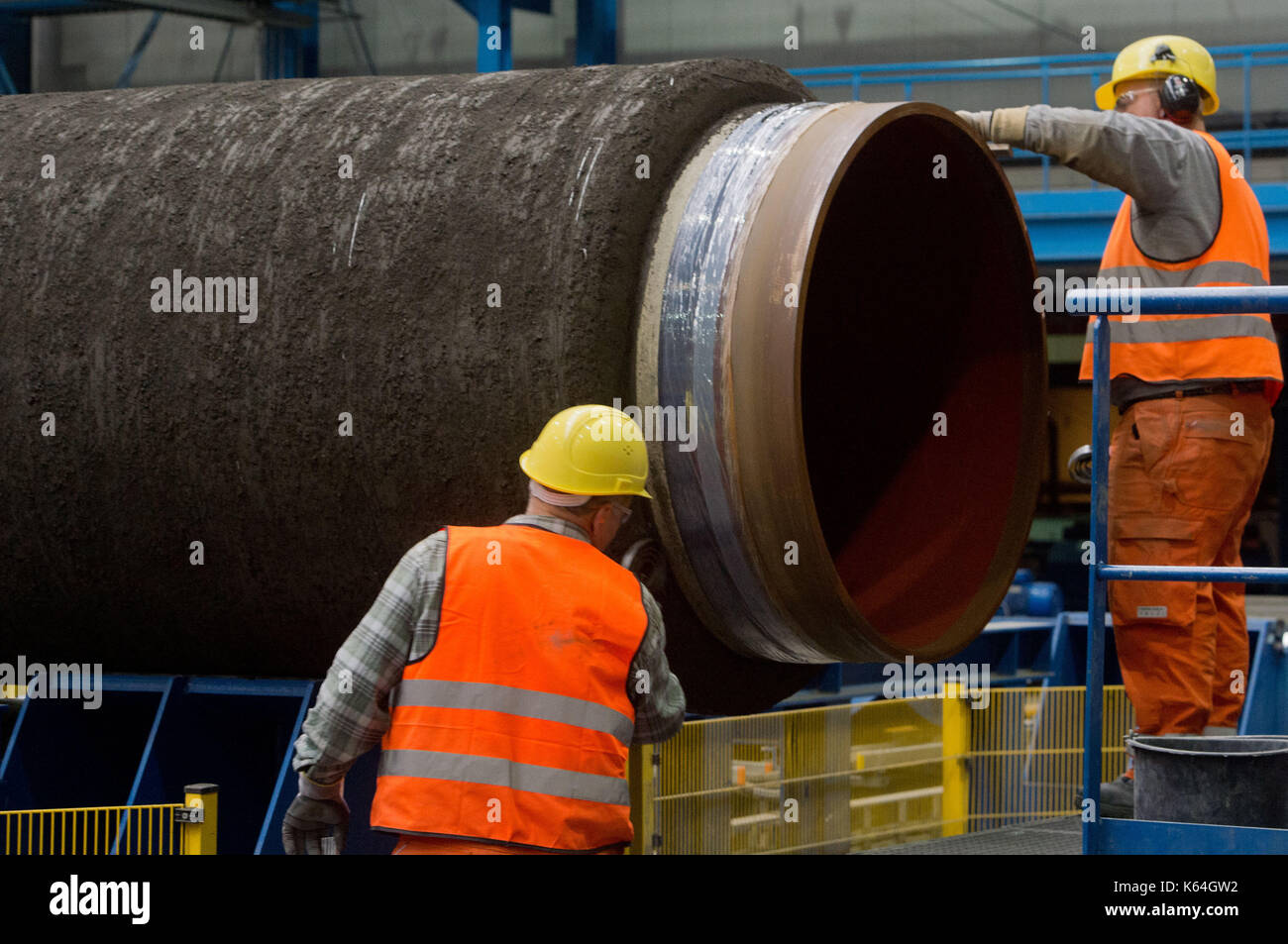 A steel pipe is being coated in concrete in the Wasco coating plant on ...
