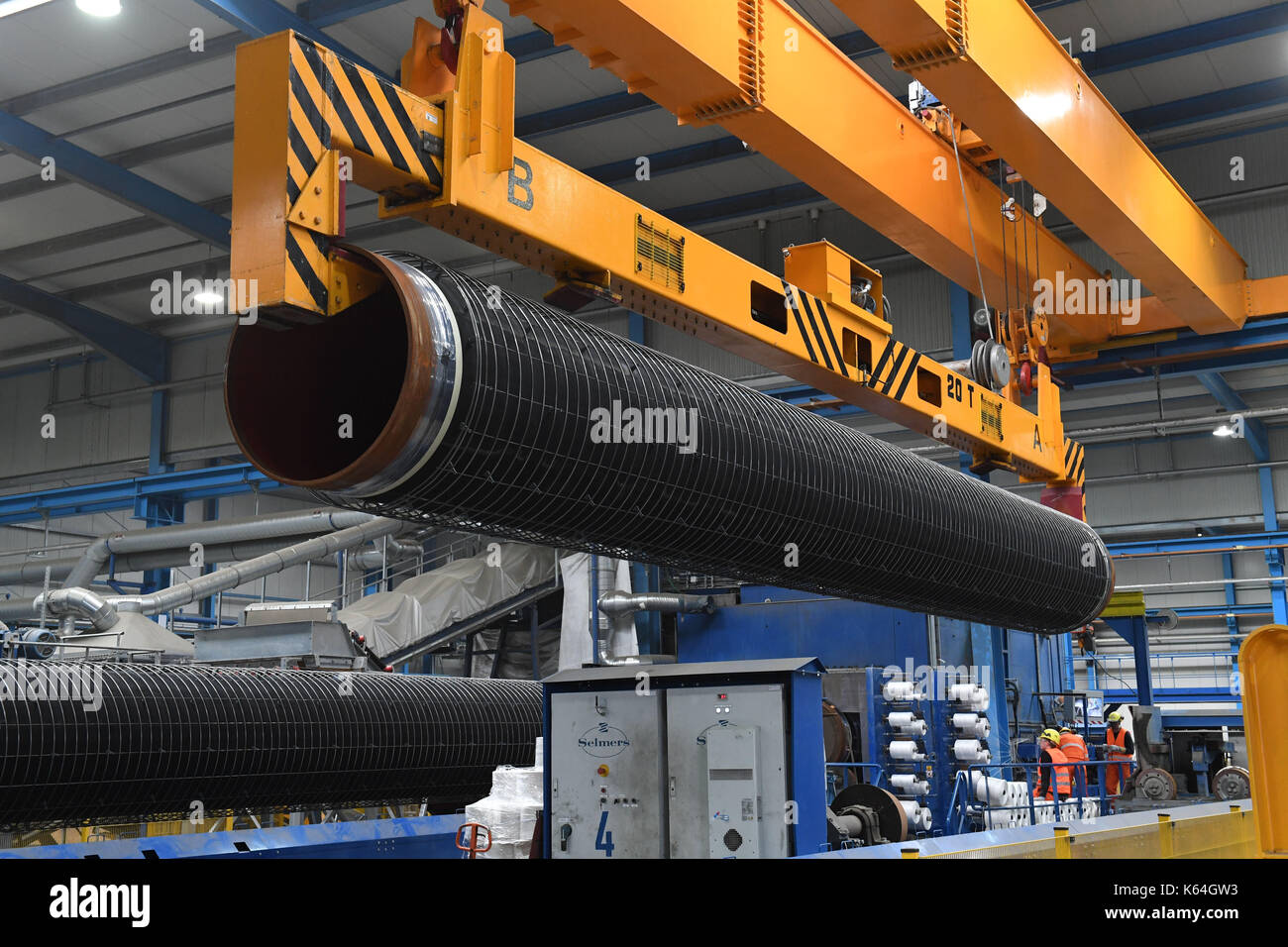 A steel pipe is being coated in concrete in the Wasco coating plant on ...