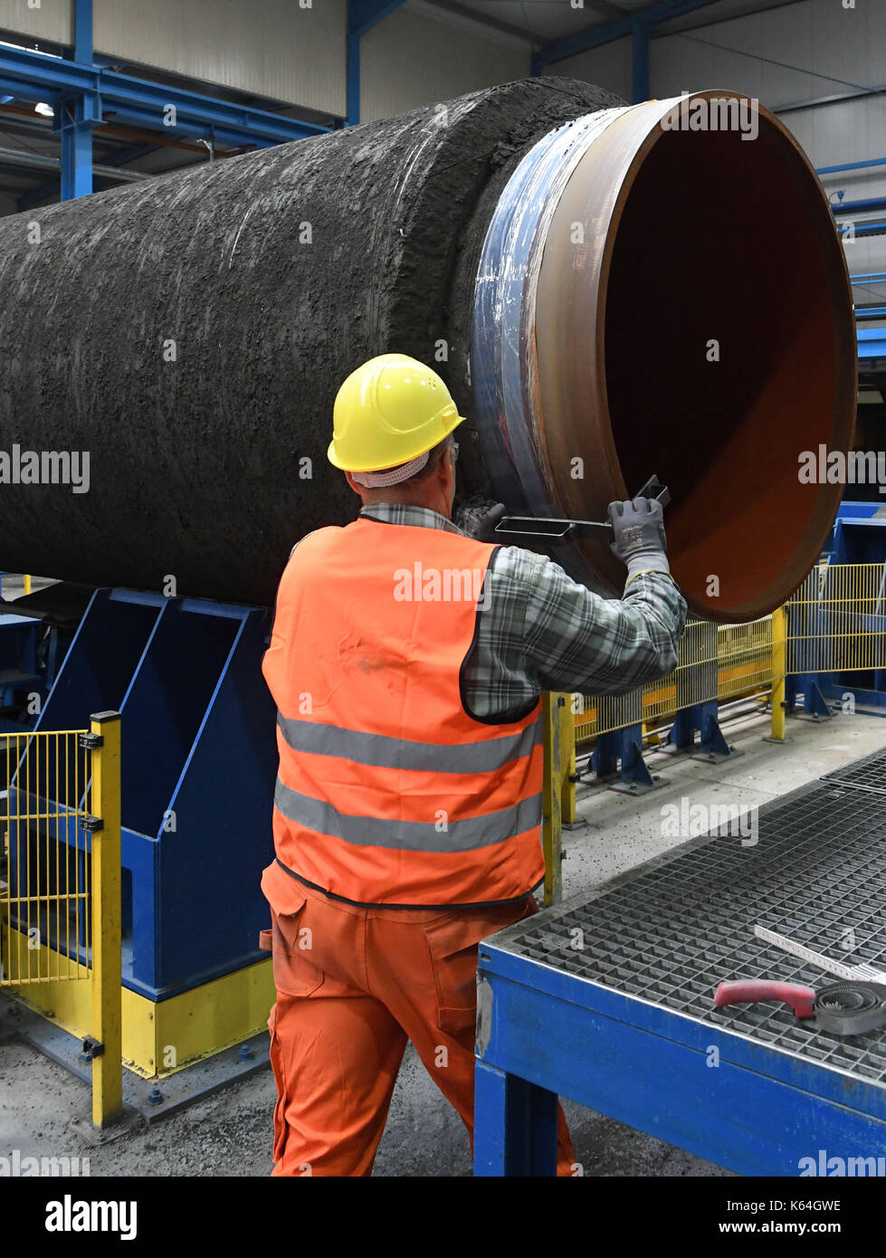 A steel pipe is being coated in concrete in the Wasco coating plant on ...