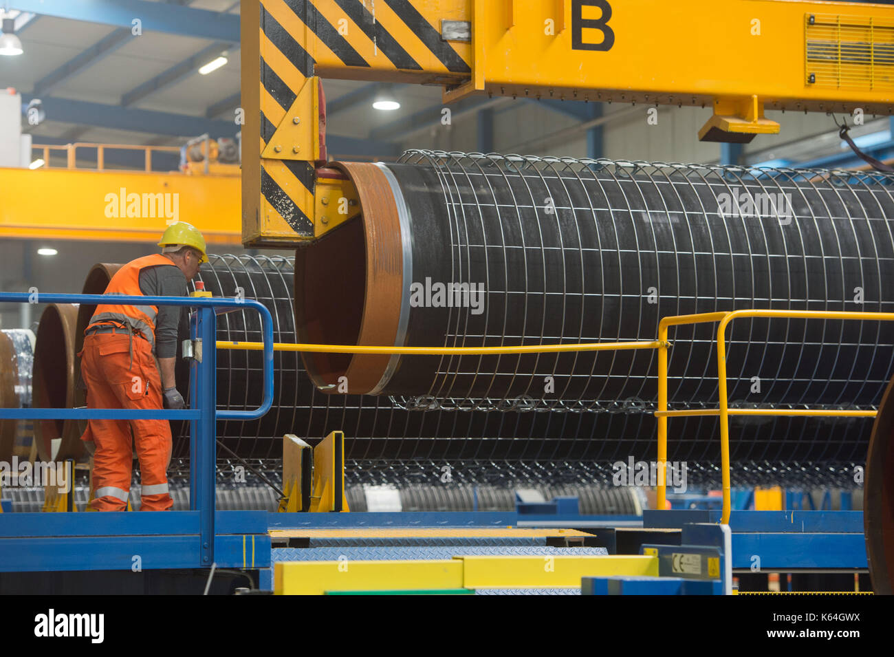 A steel pipe is being coated in concrete in the Wasco coating plant on ...
