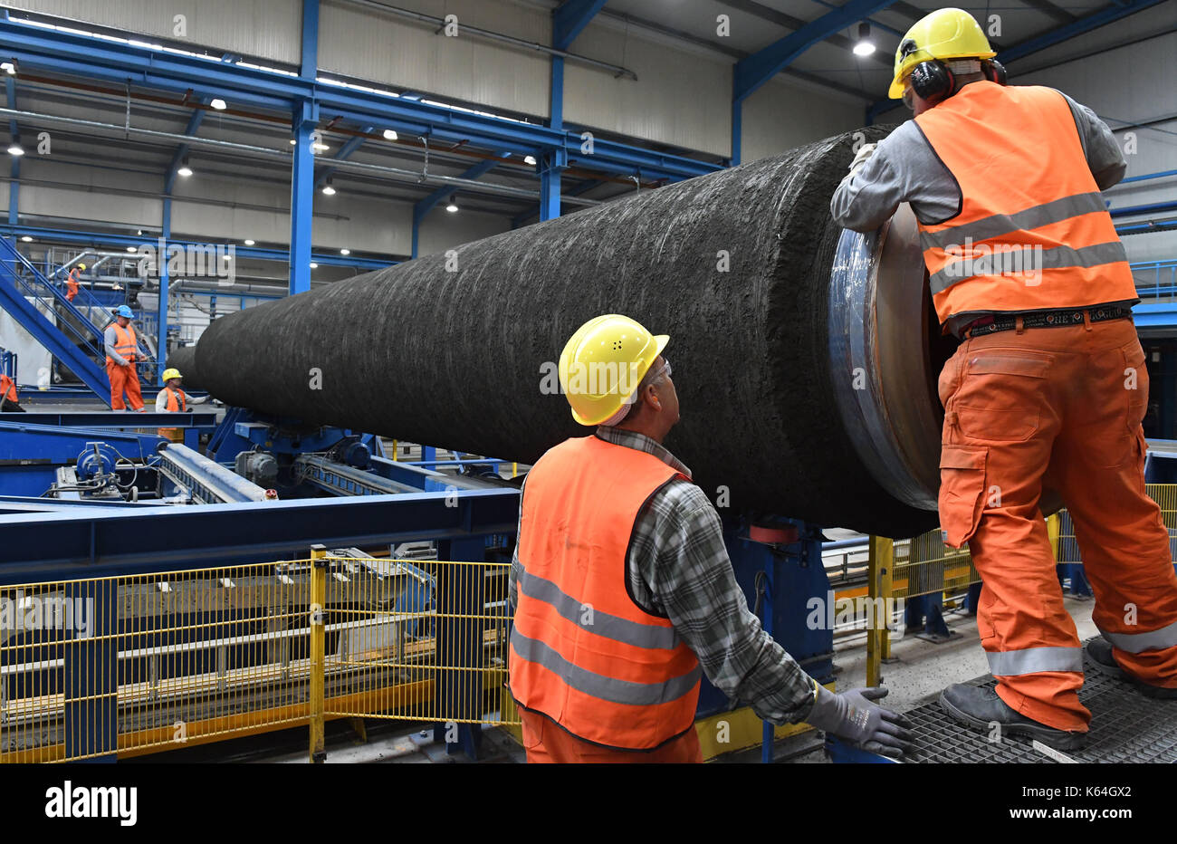 A steel pipe is being coated in concrete in the Wasco coating plant on ...