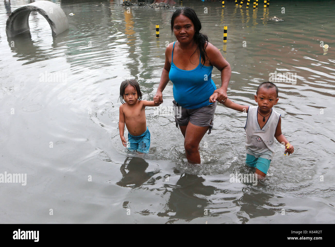 Makati City, Philippines. 12th Sep, 2017. Residents wade through flood ...