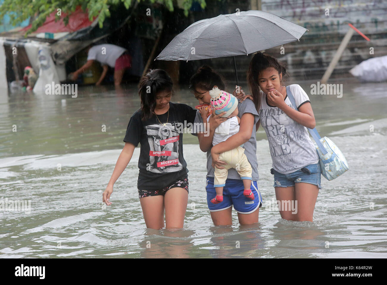 Makati City, Philippines. 12th Sep, 2017. Residents wade through flood ...