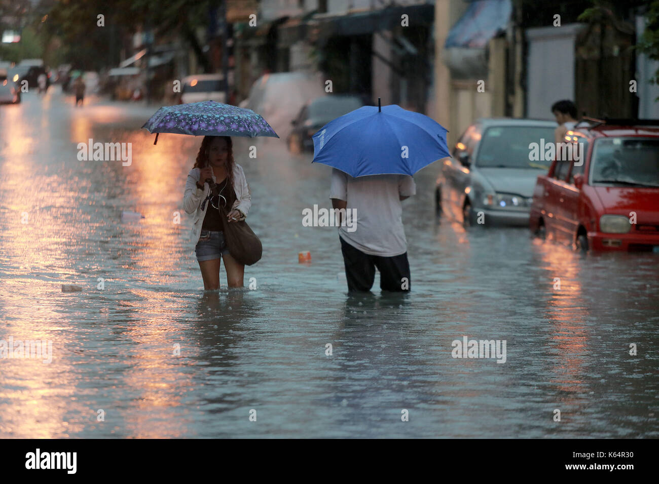 Makati City, Philippines. 12th Sep, 2017. Residents wade through flood ...