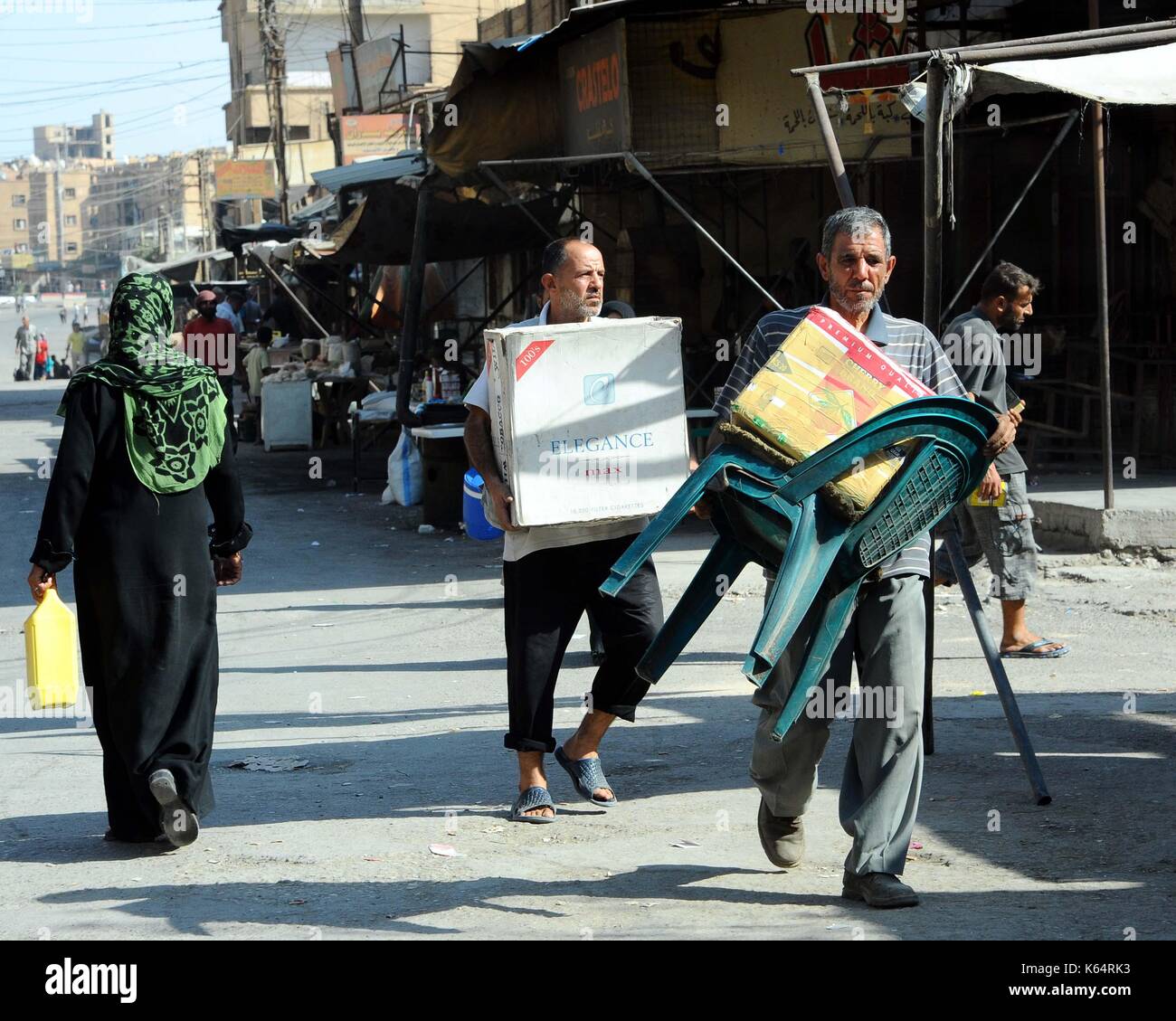 (170912) -- DEIR AL-ZOUR, Sept. 12, 2017 (Xinhua) -- People carry ...