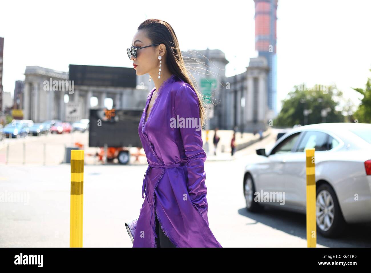 A chic showgoer posing outside of the Public School runway show during ...