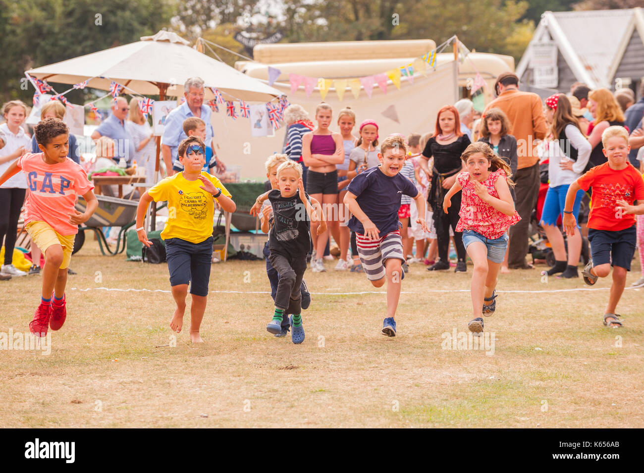 Children running a race at the village fete in Walberswick , Suffolk ...
