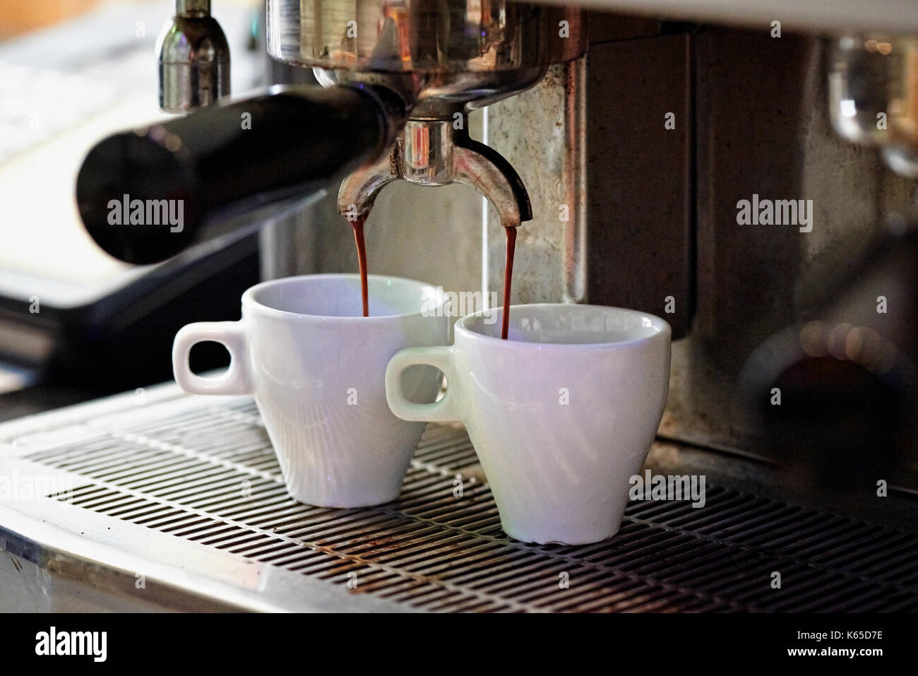 Espresso shot dropping into cup on stainless steel Espresso machine ...