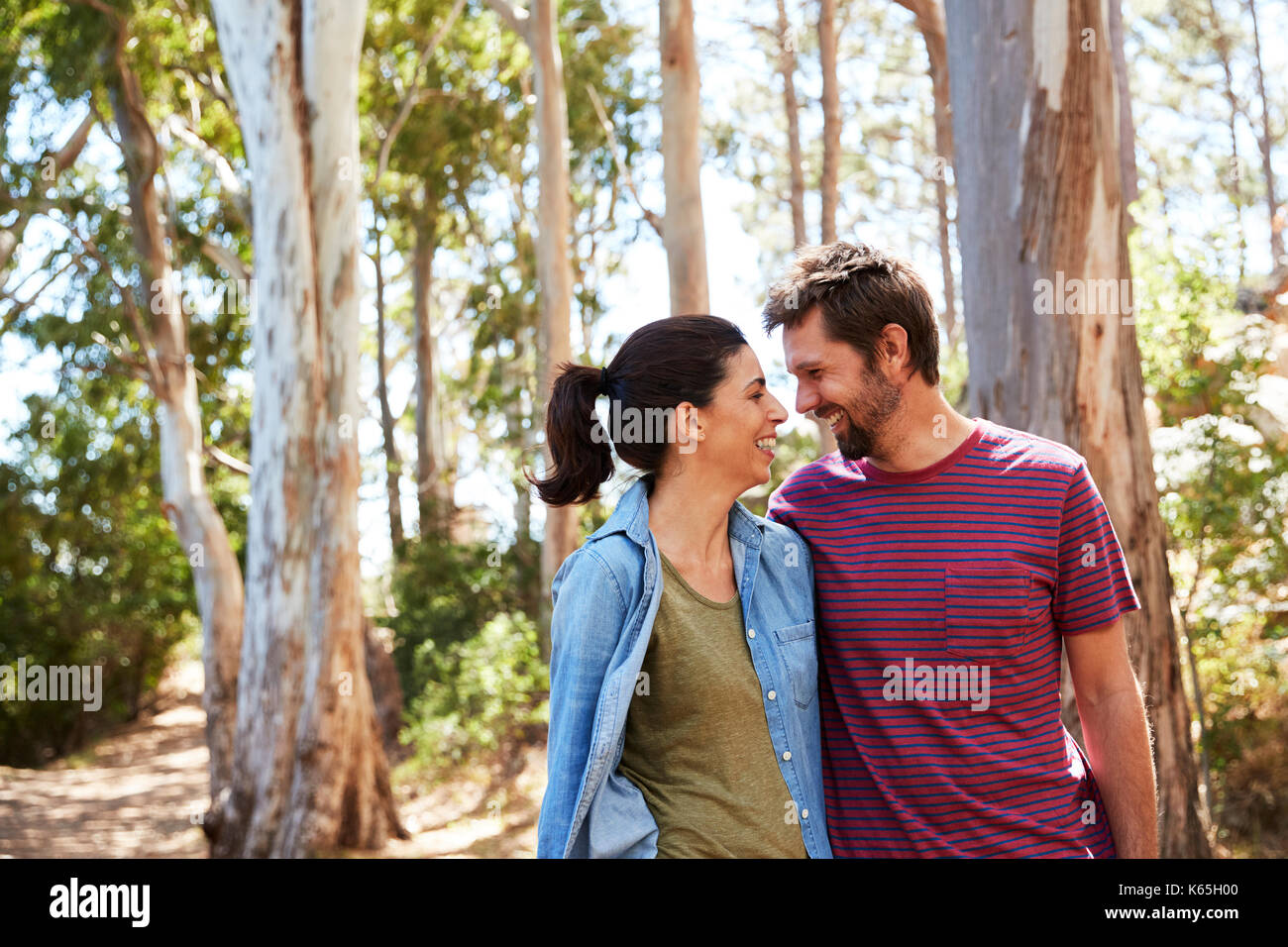 Romantic Couple Hiking Along Forest Path Together Stock Photo - Alamy