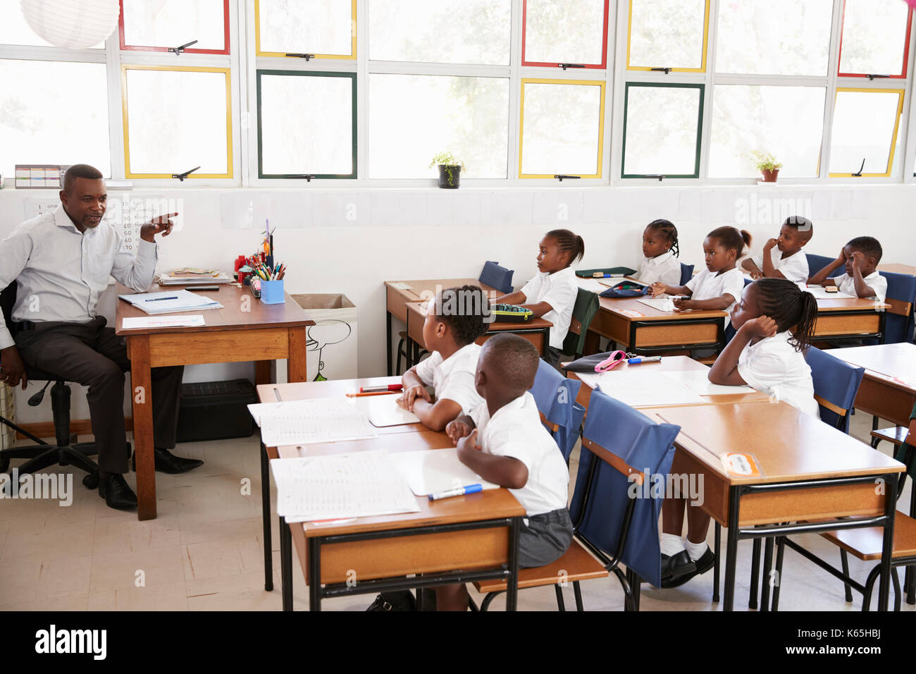Teacher teaching kids from his desk at an elementary school Stock Photo ...