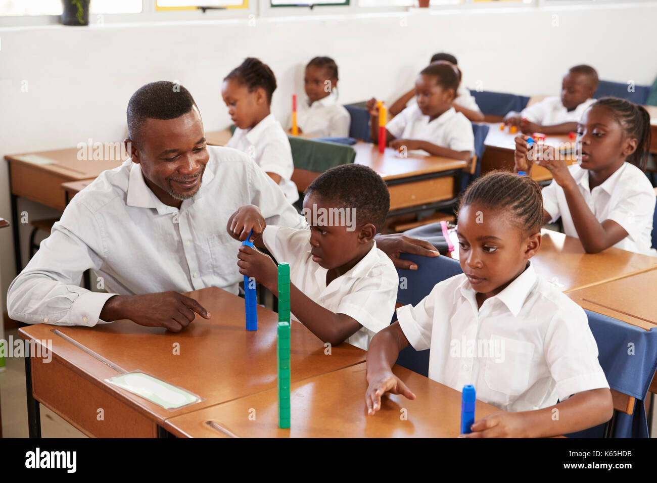 Teacher helping elementary school kids counting with blocks Stock Photo ...