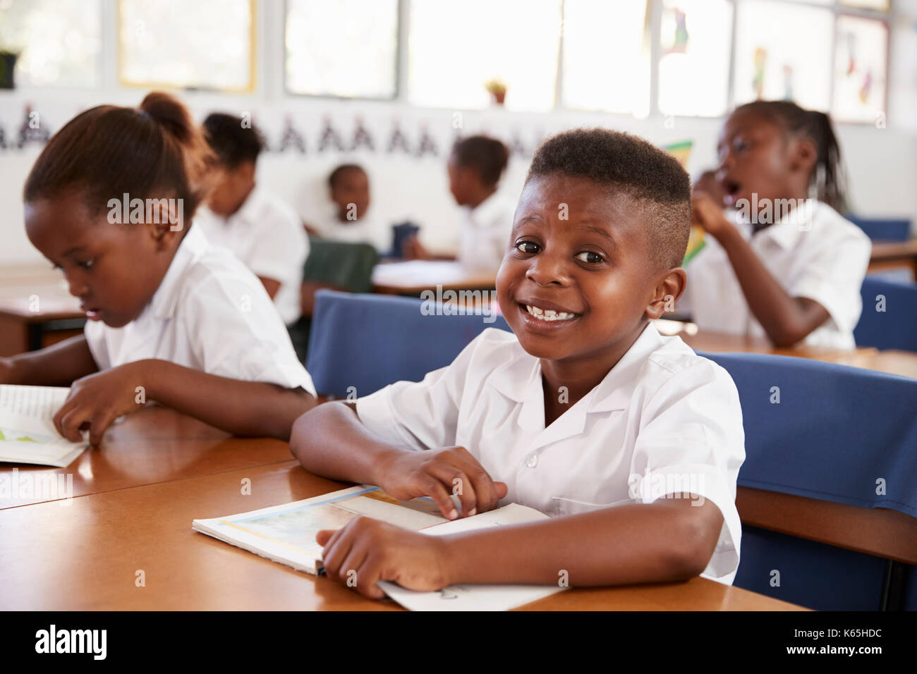 Elementary school boy smiling at camera at his desk in class Stock ...