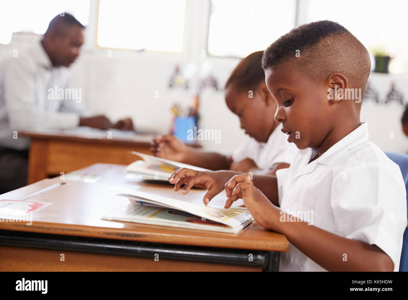 Elementary school boy reading a book in class, side view Stock Photo ...