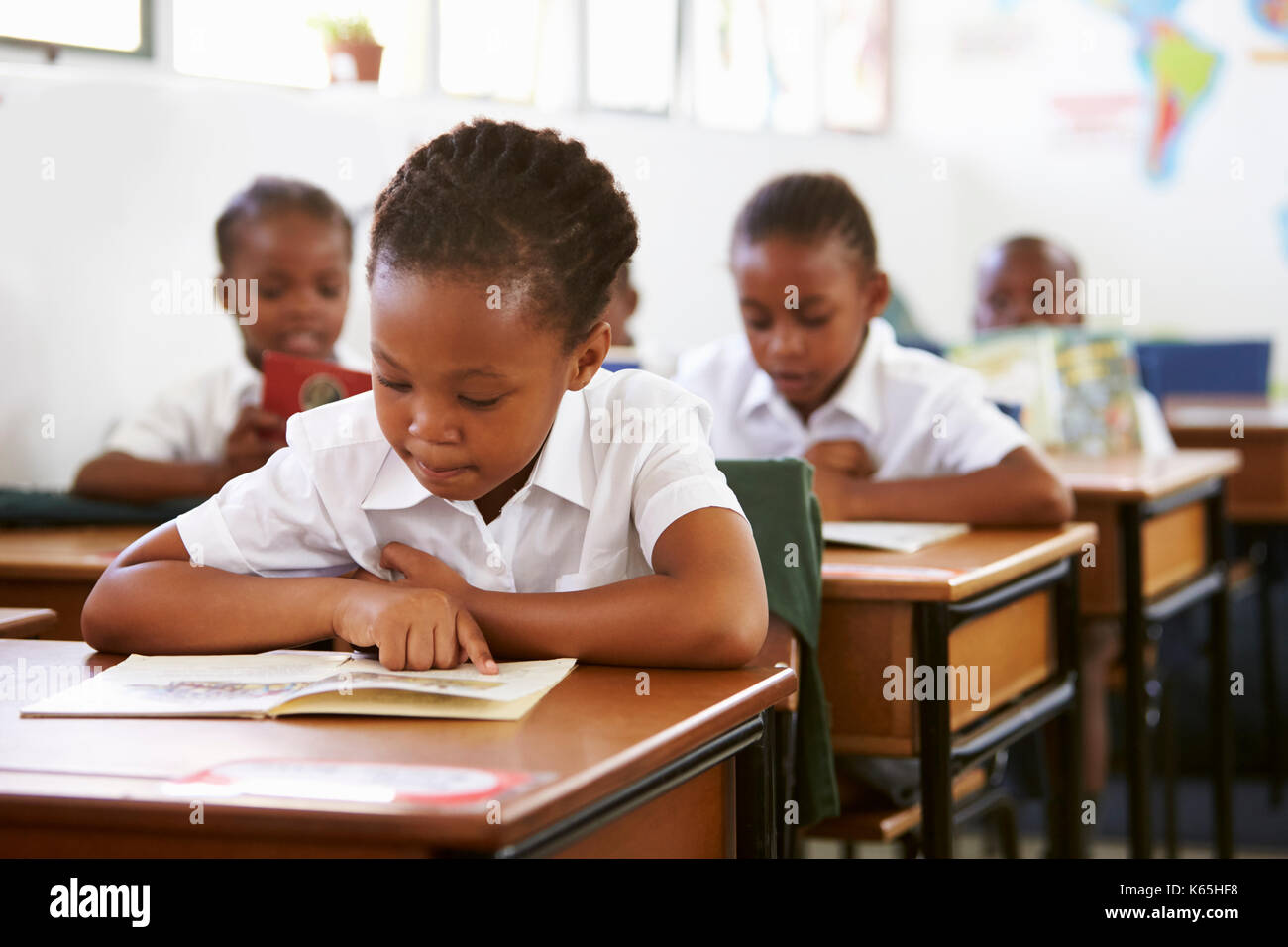 Schoolgirl reading at her desk in elementary school lesson Stock Photo ...