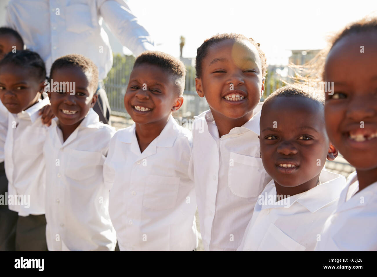 Elementary school kids smiling to camera in playground Stock Photo - Alamy