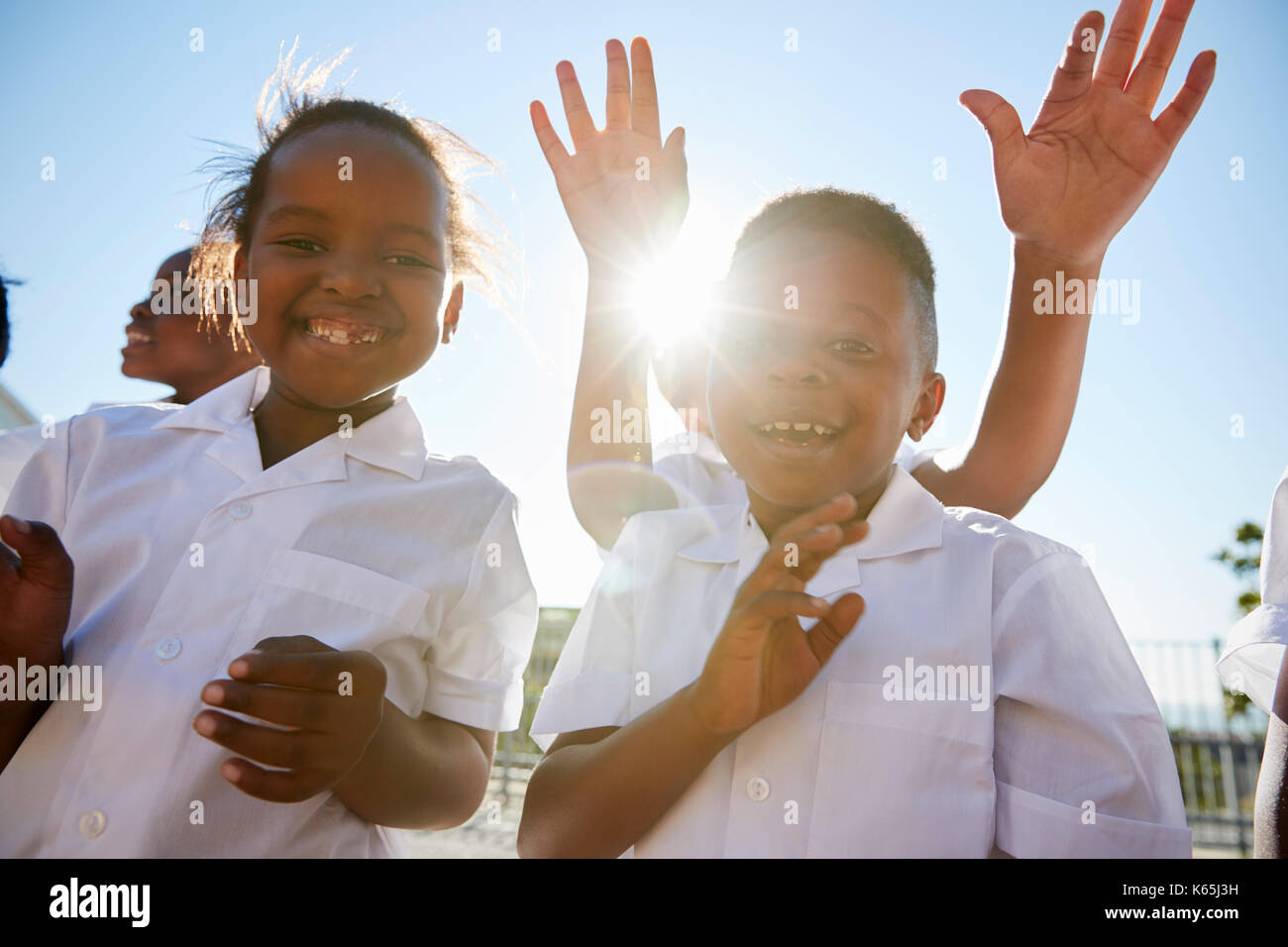 Elementary school kids in playground waving to camera Stock Photo - Alamy