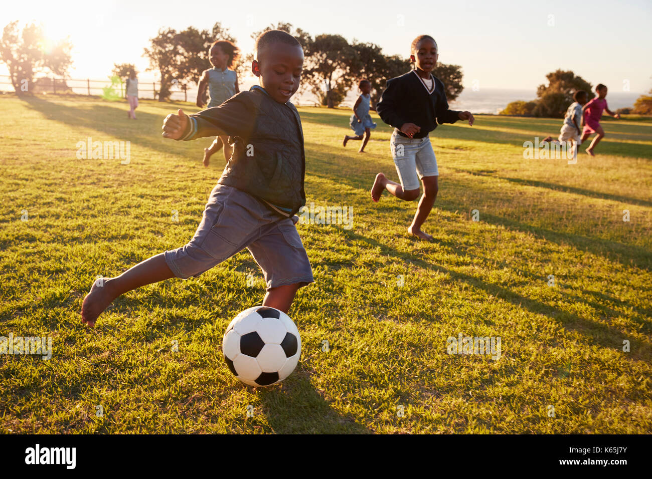 Elementary school kids playing football in a field Stock Photo - Alamy