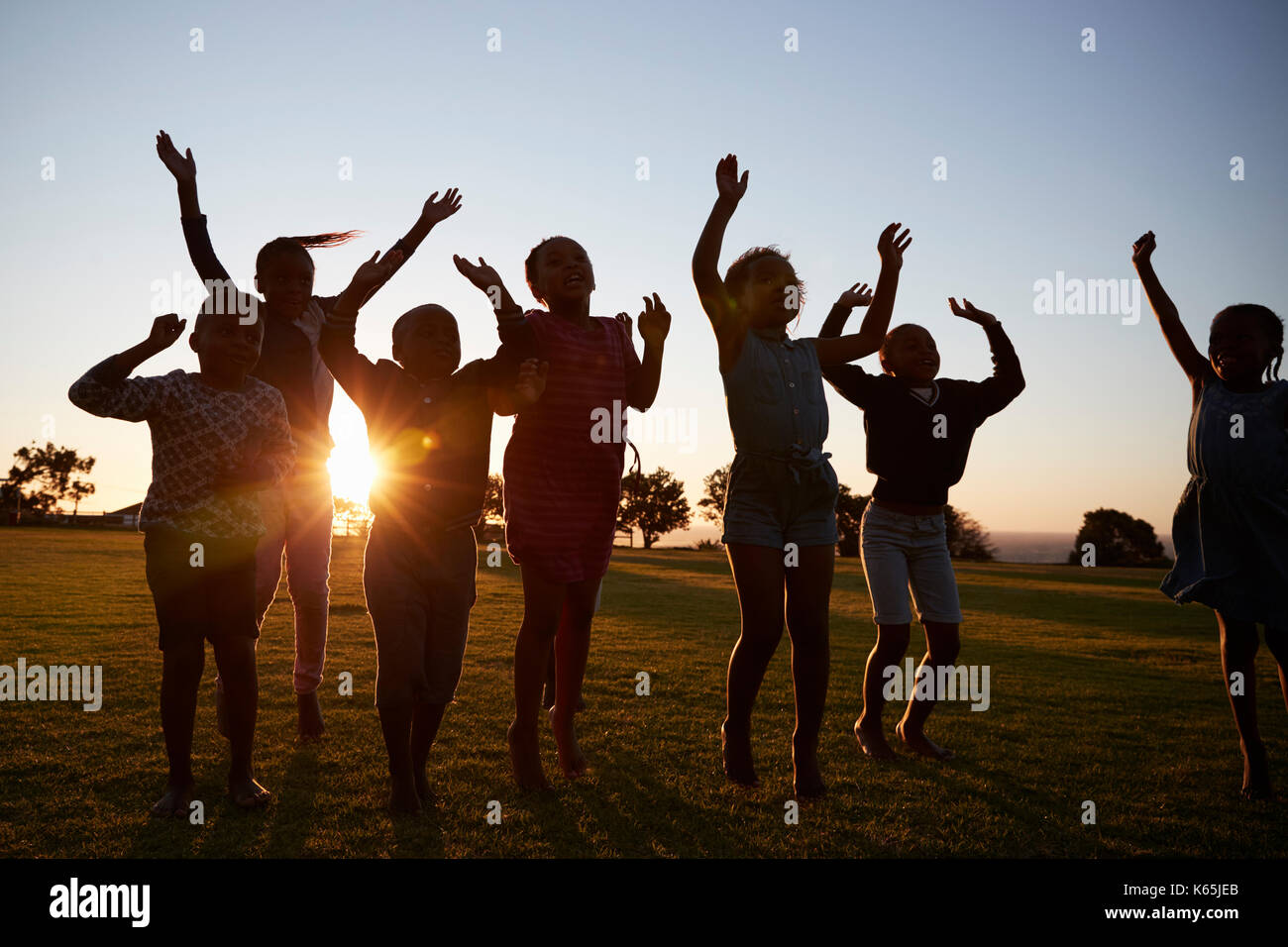 Silhouetted school kids jumping outdoors at sunset Stock Photo - Alamy