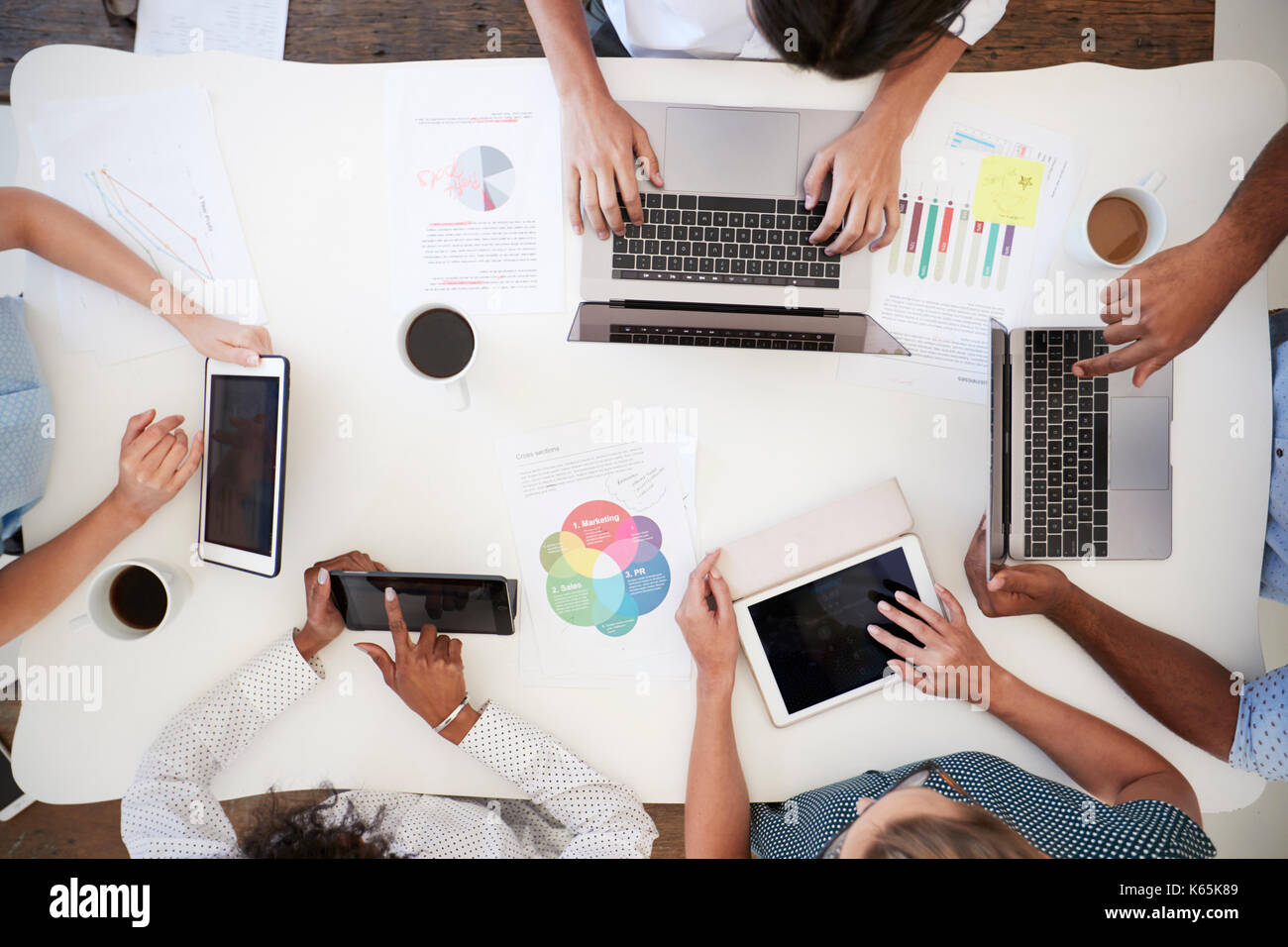 Business people using computers at a desk, overhead shot Stock Photo ...
