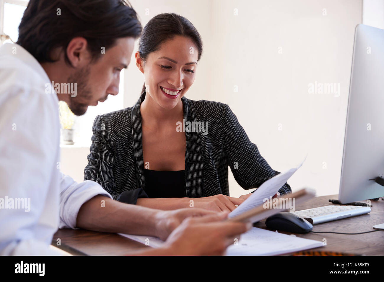 Man and woman looking at documents in an office, close up Stock Photo ...