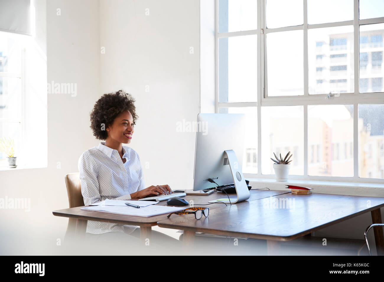 Young black woman working at computer in an office Stock Photo - Alamy