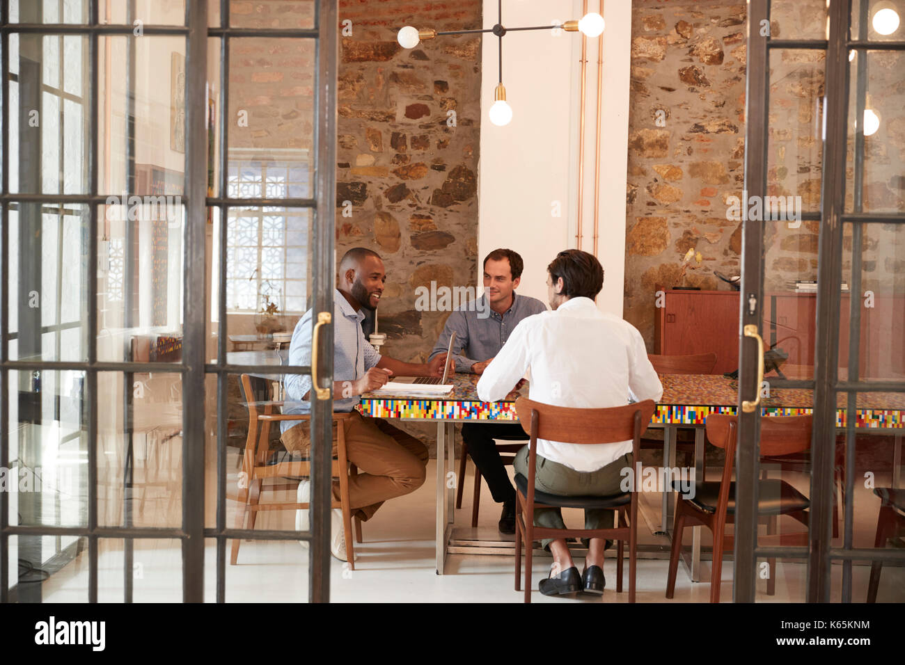 Three young men at a meeting in a boardroom, close up Stock Photo - Alamy