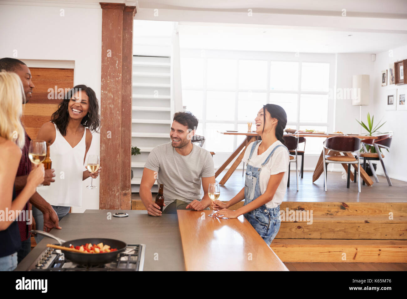 Friends Prepare And Serve Food For Dinner Party At Home Together Stock ...