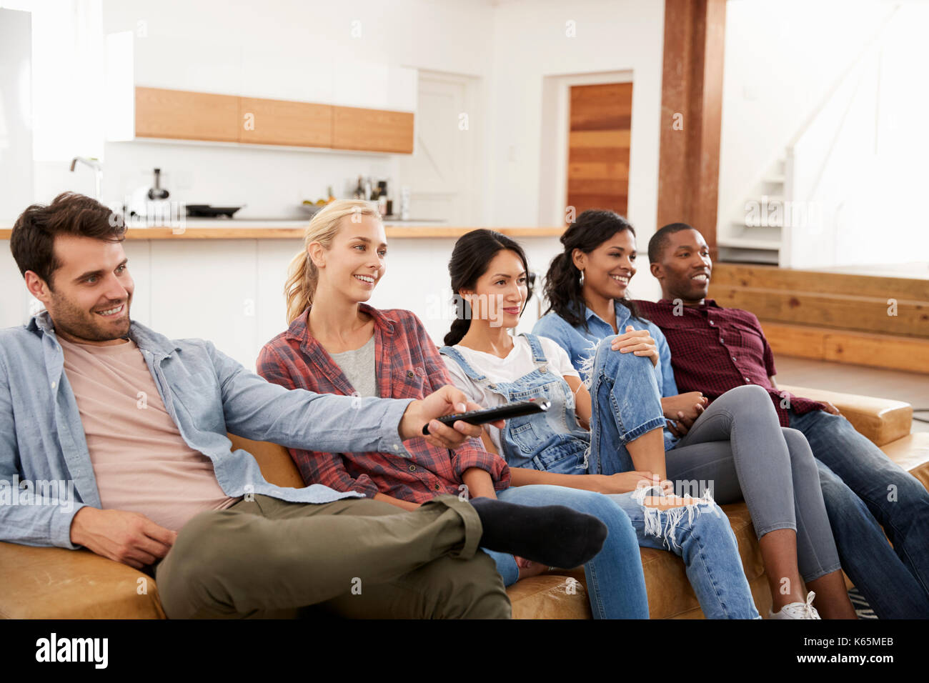 Group Of Friends Sitting On Sofa Watching Television Together Stock ...