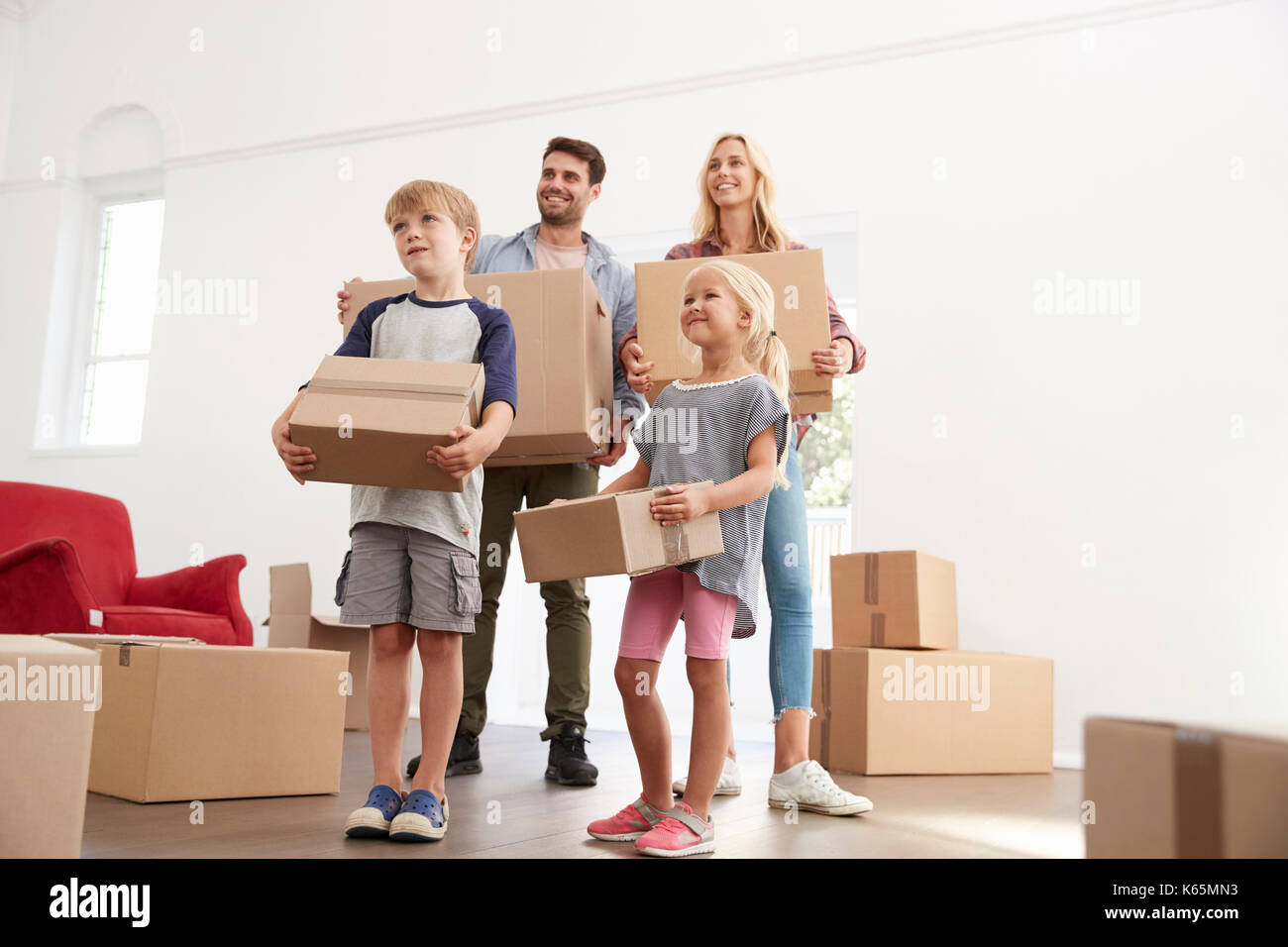 Family Unpacking Boxes In New Home On Moving Day Stock Photo - Alamy