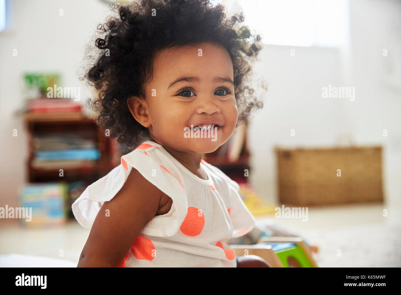 Happy Baby Girl Playing With Toys In Playroom Stock Photo - Alamy