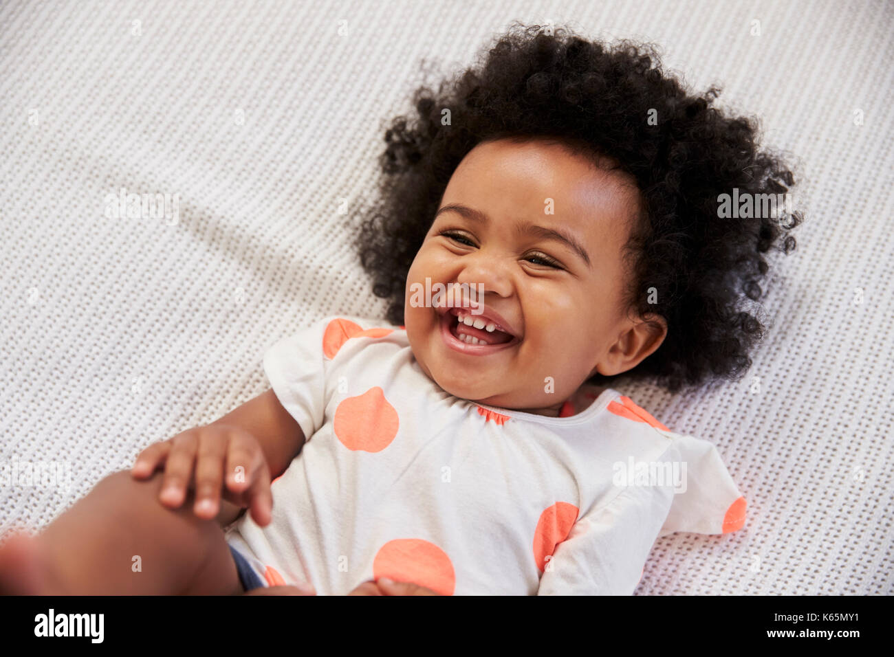 Parent Tickling Laughing Baby Girl Lying On Bed Stock Photo - Alamy