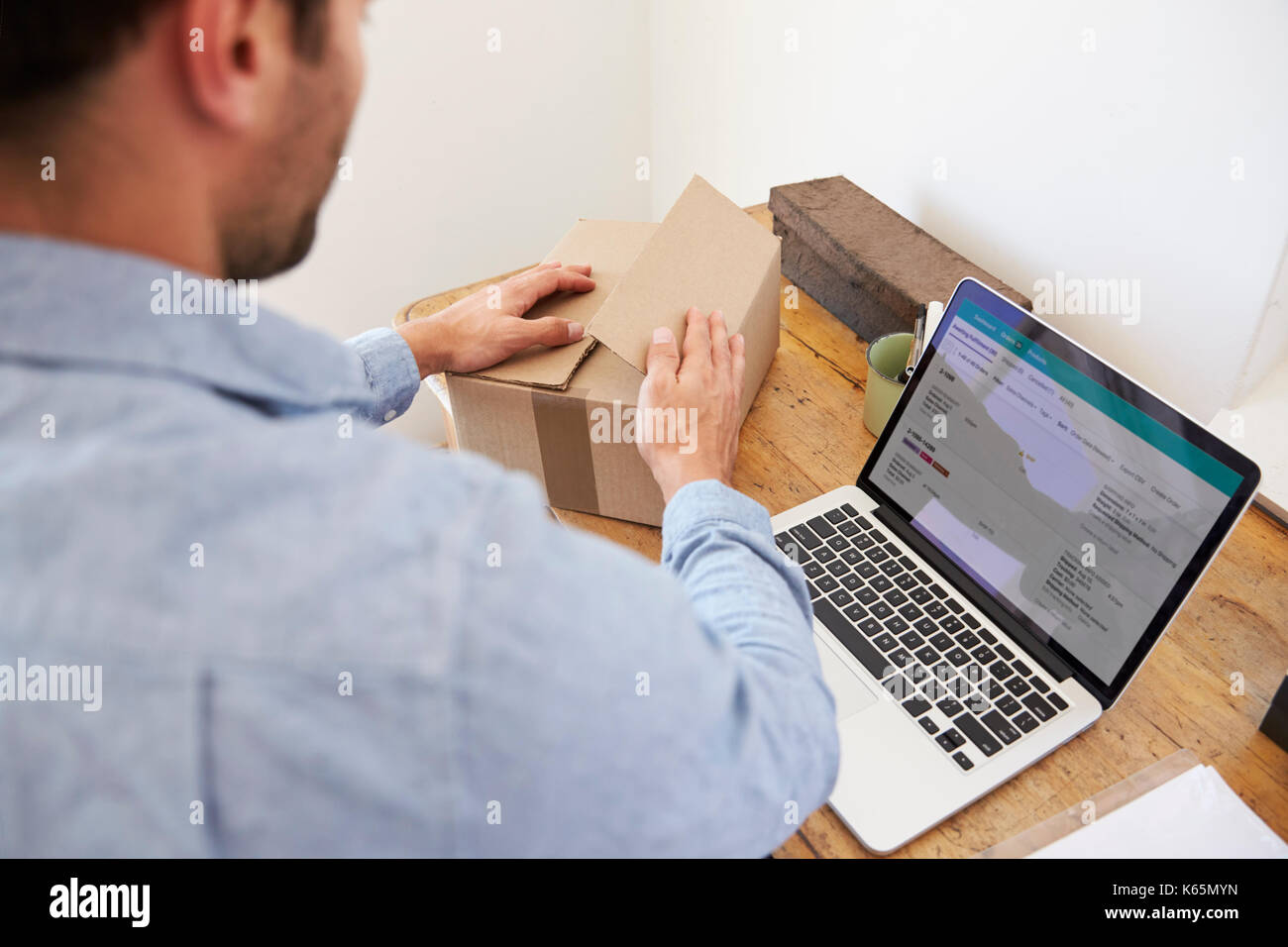 Rear View Of Man Running Business From Home Dispatching Goods Stock ...