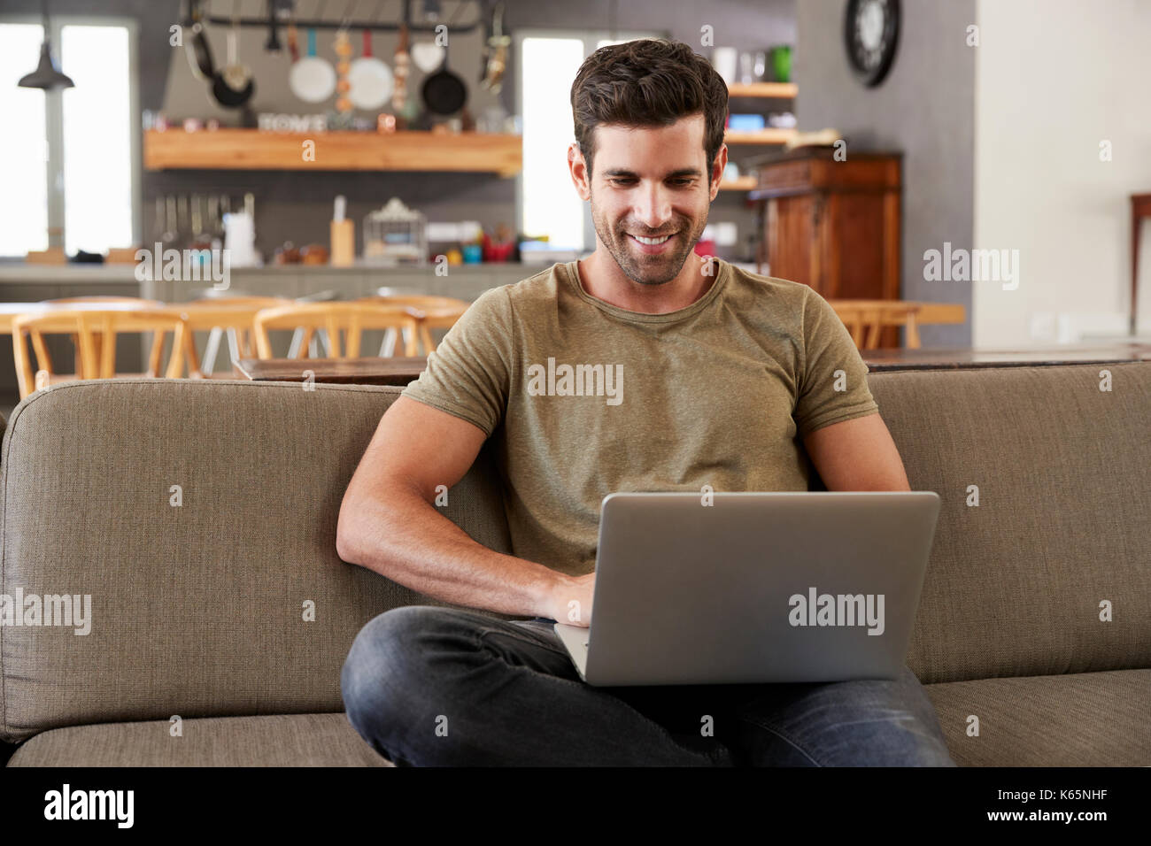 Man Sitting On Lounge Sofa Using Laptop Stock Photo - Alamy