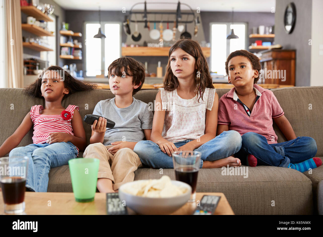 Group Of Children Sitting On Sofa Watching Television Together Stock ...