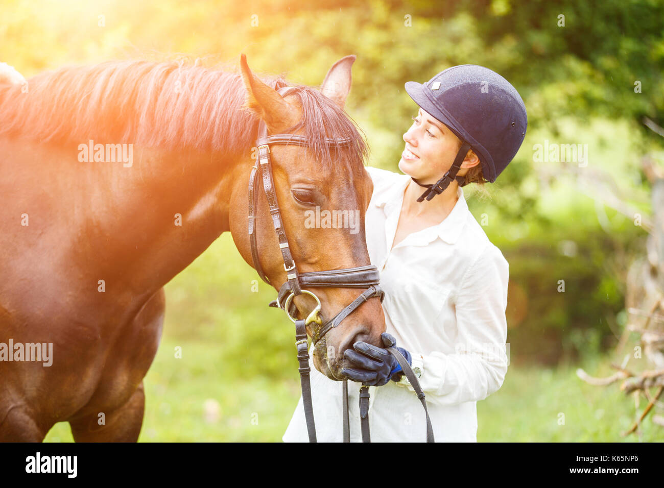 Young beautiful rider woman in helmet holding bay horse by bridle Stock ...