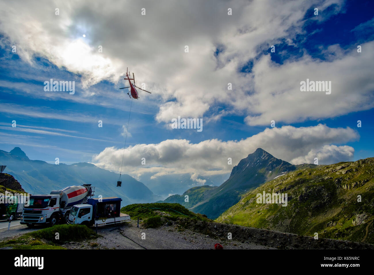A helicopter of the company Swiss Helicopters is transporting concrete ...