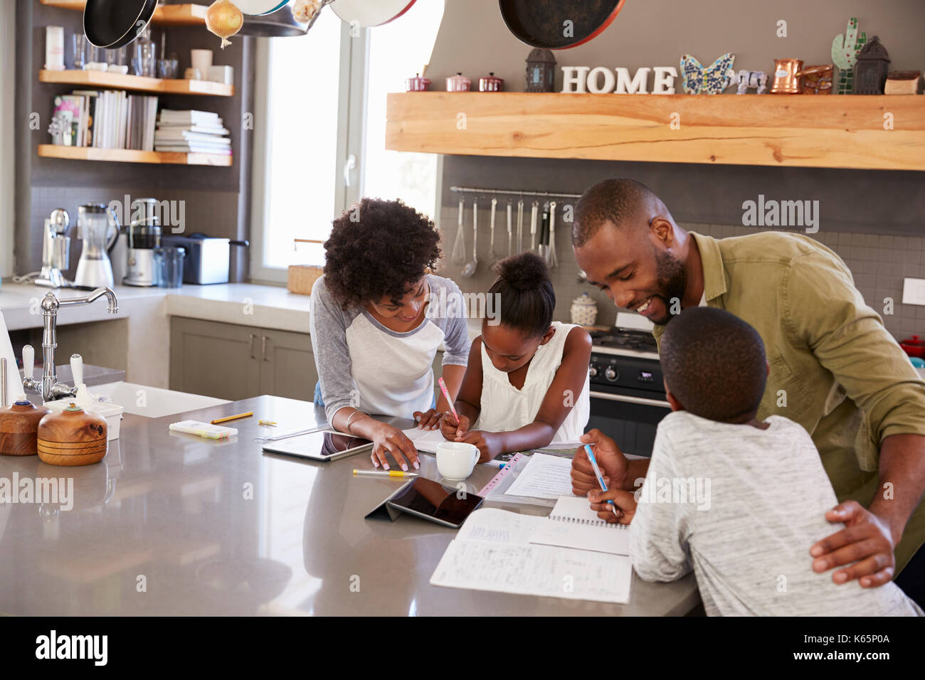 Parents Helping Children With Homework In Kitchen Stock Photo - Alamy